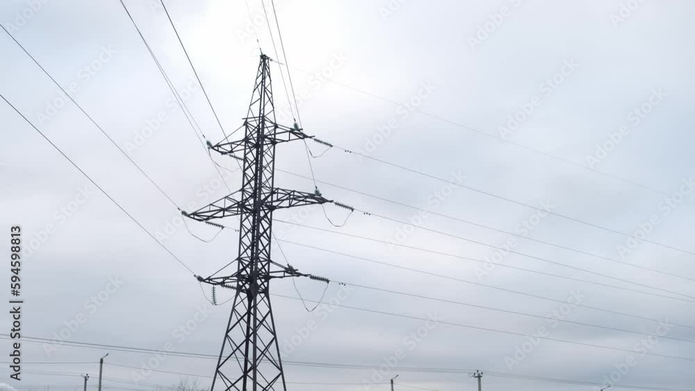 High voltage electric tower with wires on overcast sky background ...