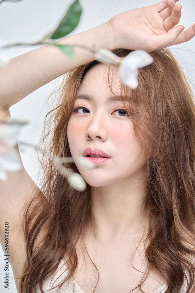 Beautiful Young Asian woman behind flower in beauty pose. Pretty girl ...