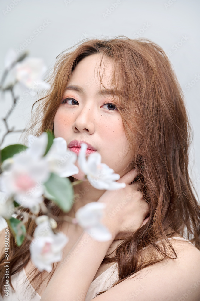 Beautiful Young Asian woman behind flower in beauty pose. Pretty girl ...