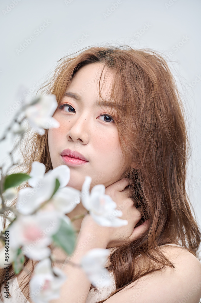 Beautiful Young Asian woman behind flower in beauty pose. Pretty girl ...