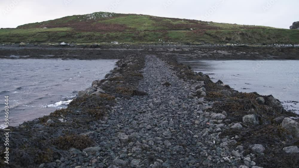 Static shot of an ancient stone causeway joining one island to another ...