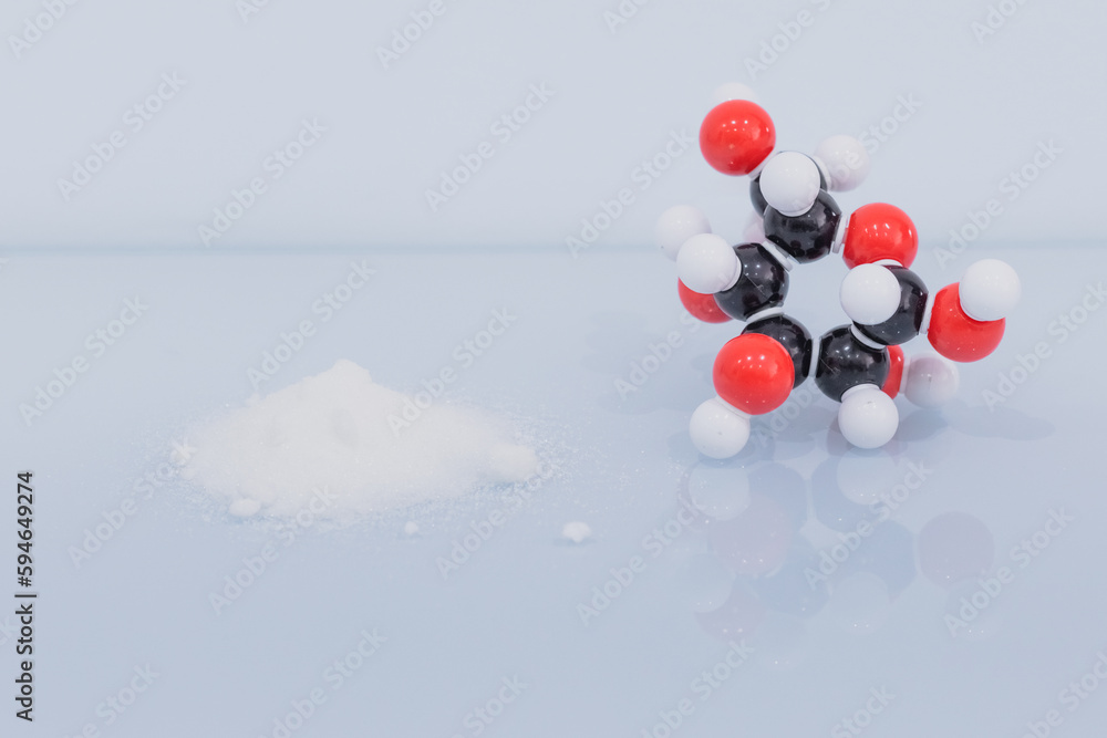 Isolated glucose molecule made by molecular model next to a little heap ...