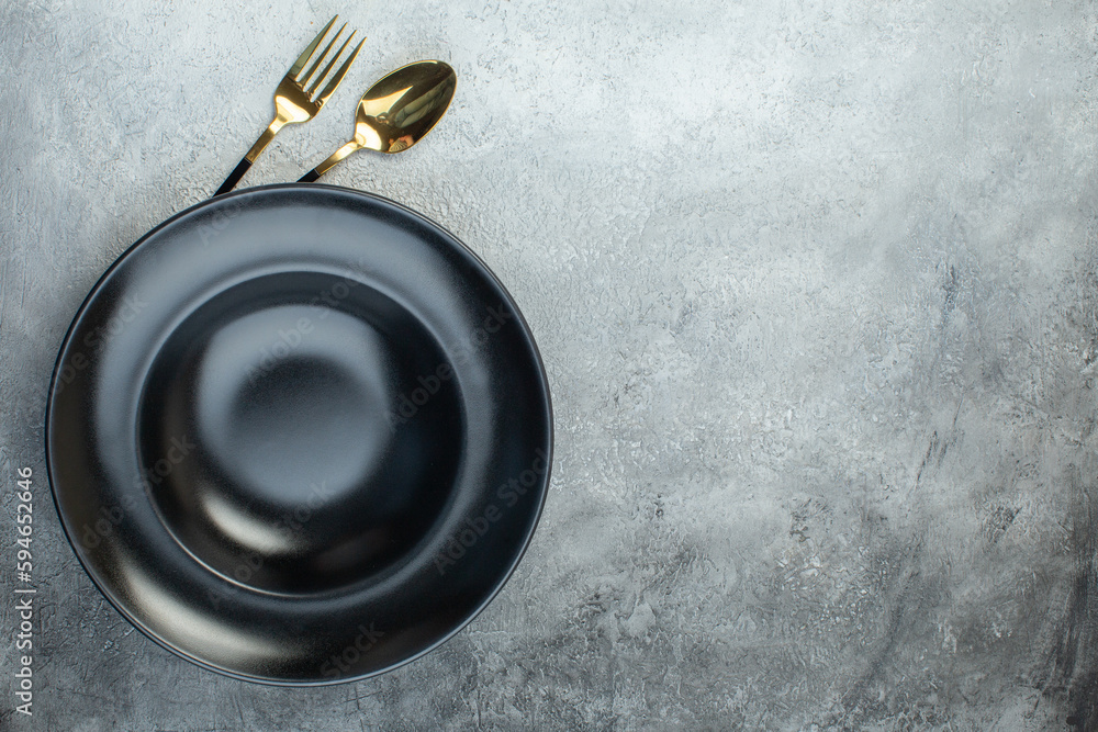 Elegant cutlery set under black dinnerware set on the right side on ...