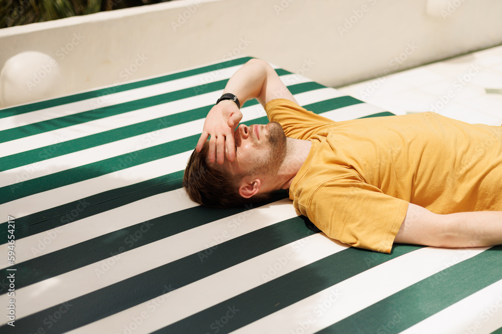 Young man laying by pool heat wave. People fatigue from work. Summer ...