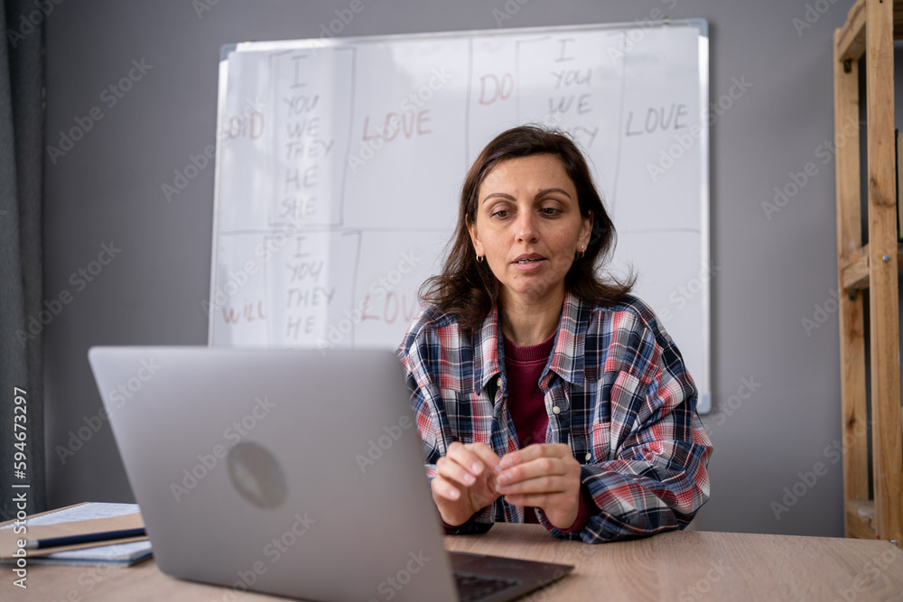 Professional female English teacher or tutor having video call ...