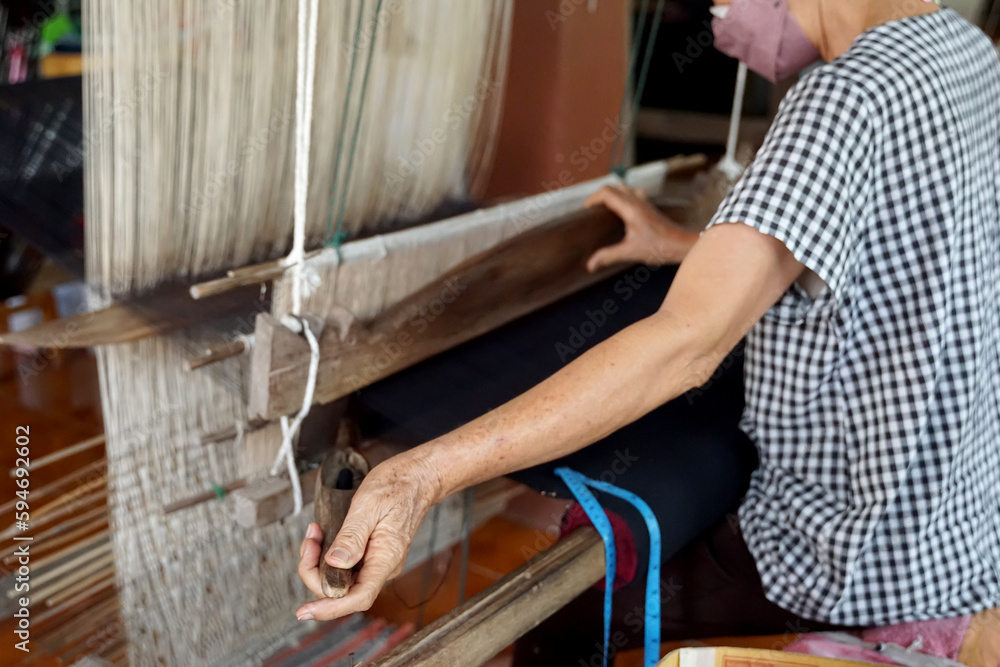 Asian female weavers weaving traditional patterns with hand weaving ...