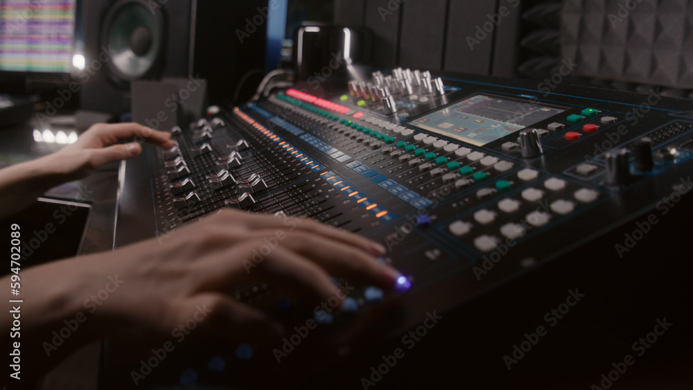 Audio engineer uses mixing console, remote control for adjusting sound ...
