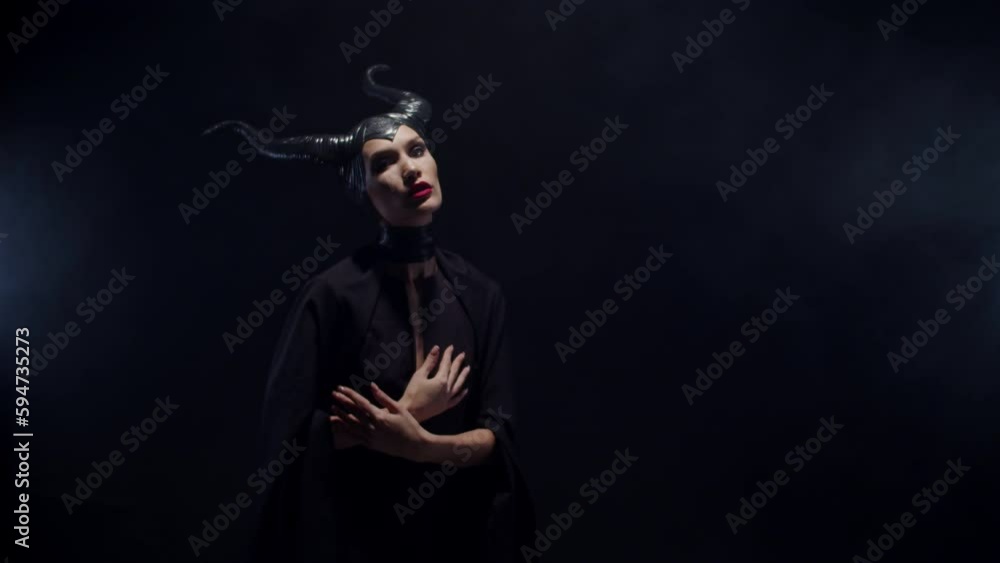 Beautiful woman cosplayer in demoness costume posing on black ...