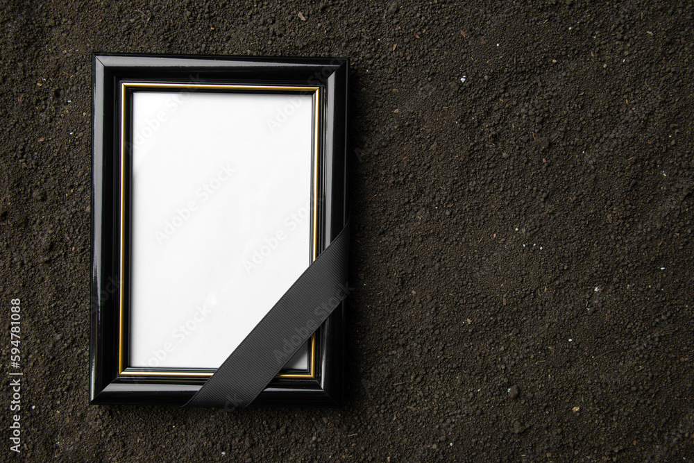 top view of picture frame on a dark soil grim reaper funeral death ...