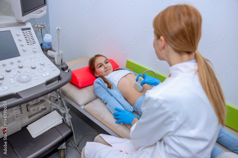 Doctor performing ultrasound scan on little girl medical specialist ...
