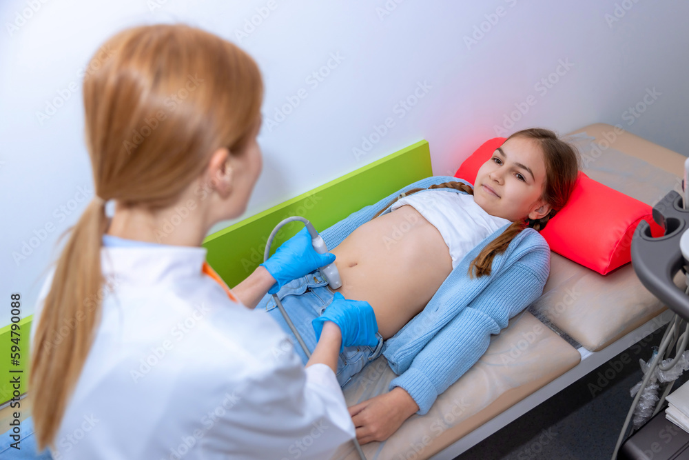 Foto de Doctor performing ultrasound scan on little girl medical specialist examining child ...