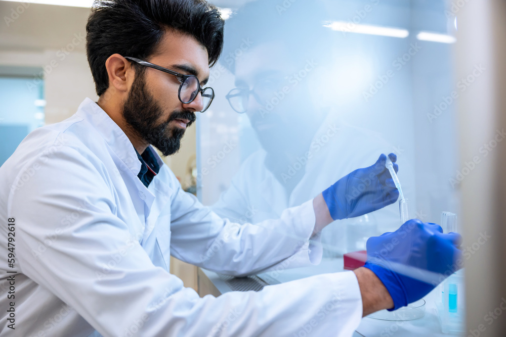 Scientist man testing chemical sample in flask at laboratory with lab ...