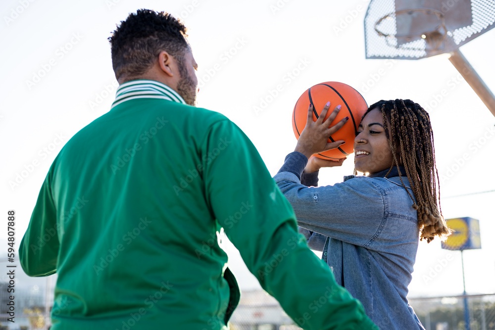 Two dark-skinned young men of different ethnicities are playing ...