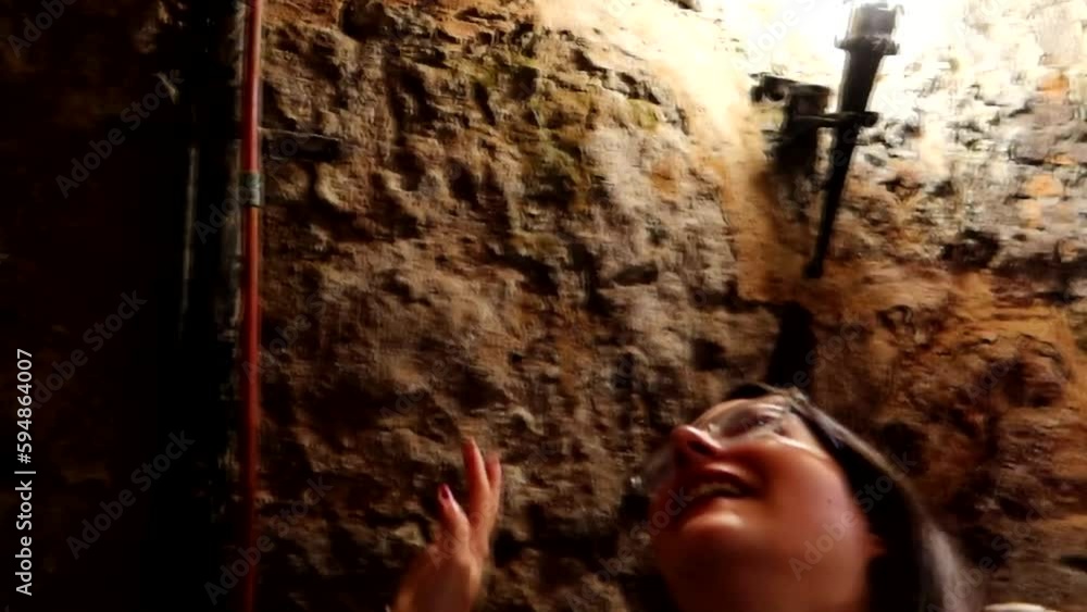Woman shows where an air shaft is located inside of a wine cellar in ...