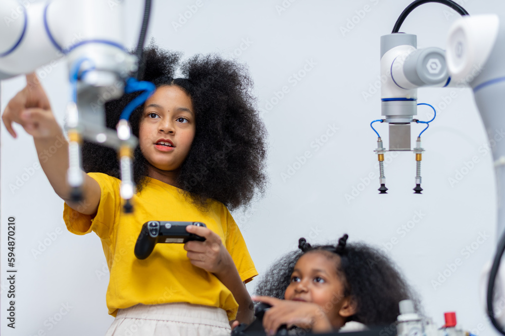 Kid female teen child enjoy Machine Learning Robot arm is Moving Under Control robot at ...