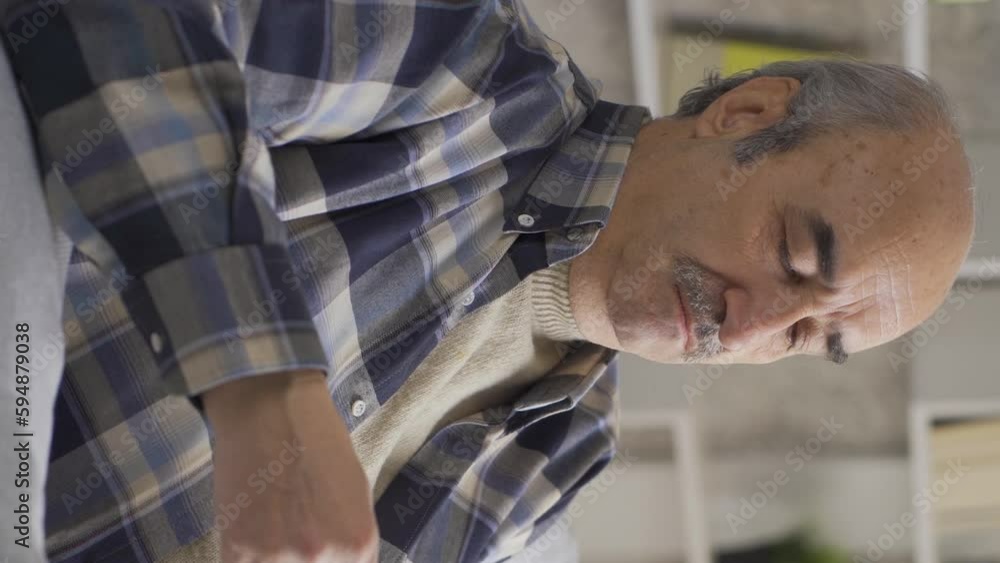 Vertical Video of The sad old man opens the letter and gets emotional ...