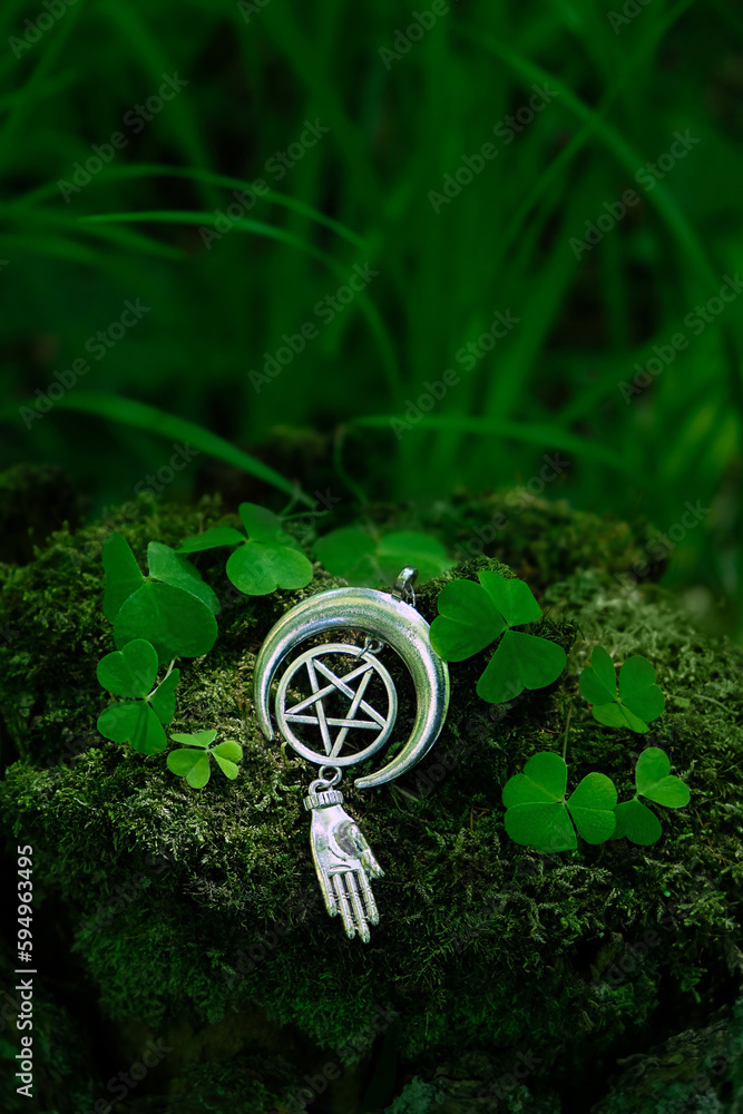 amulet with pentagram on abstract natural dark forest background ...