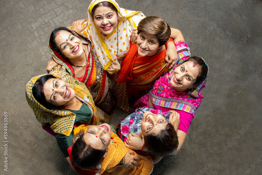 Group of happy young traditional indian women wearing colorful sari ...