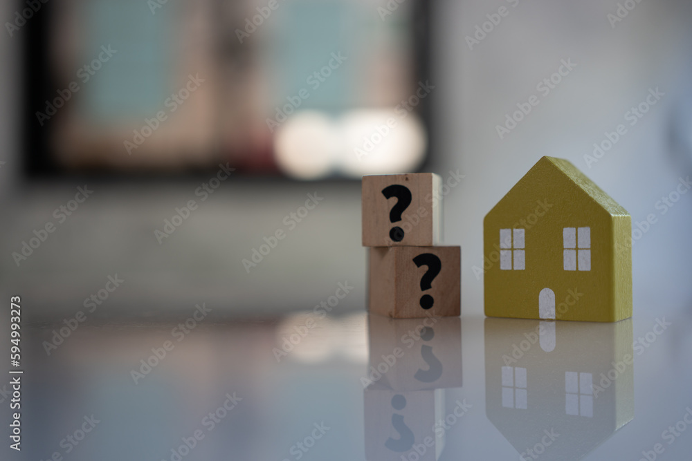 Green wooden house model and question marks with free copy space for ...