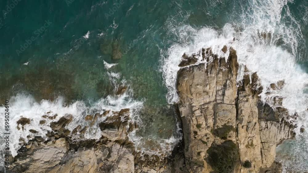 A top down aerial view of rocks and sea provides a stunning visual ...