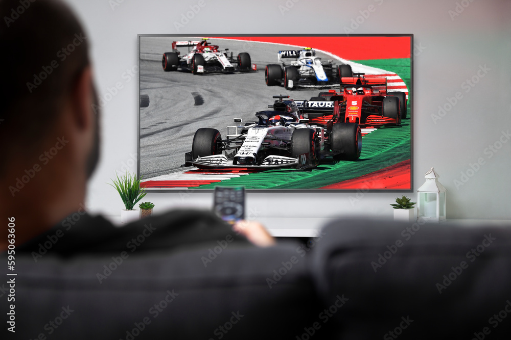 Man watching formula racing on smart TV. Live racing transmission ...