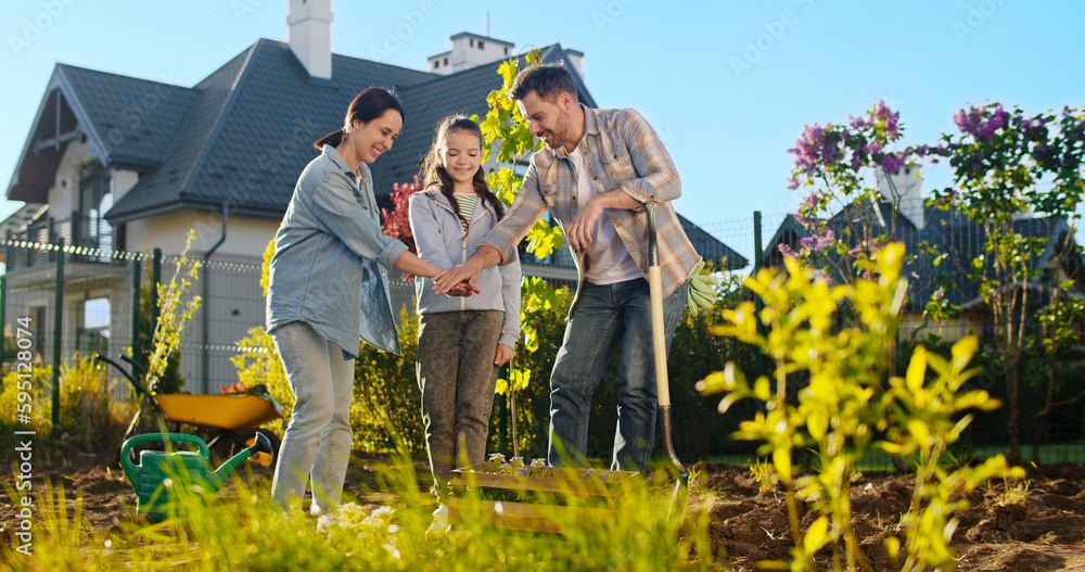 Caucasian happy joyful family planting trees together in garden. Summer ...