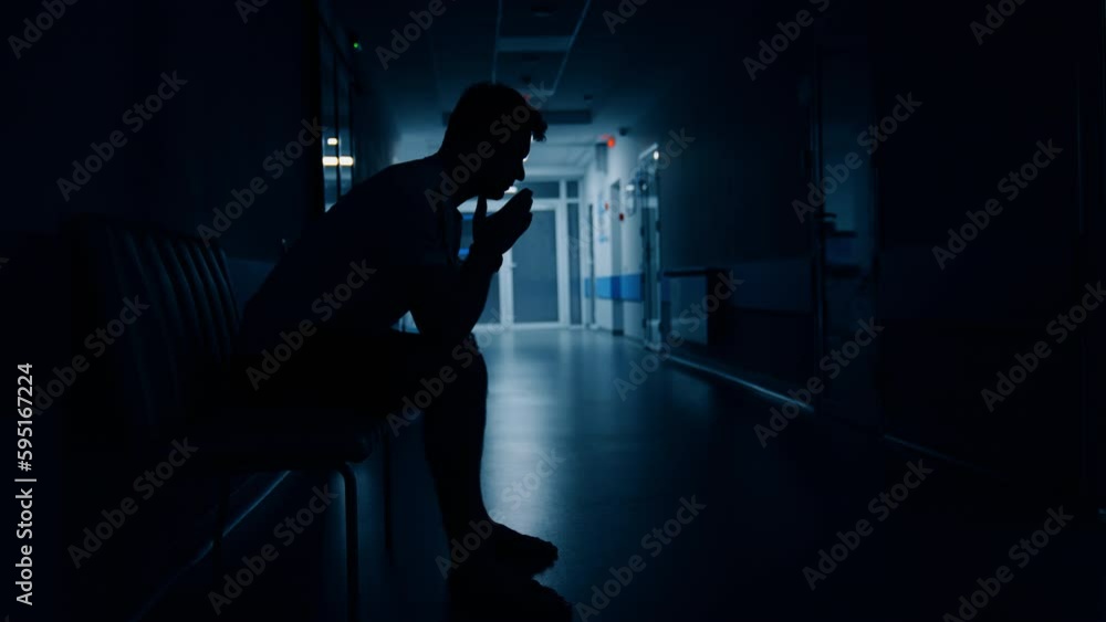 Man sitting in the dark corridor of the maternity hospital. Husband is ...