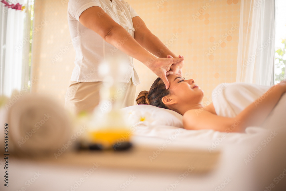Far view of beautiful asian woman being massaged with smiling face by professional masseuse ...