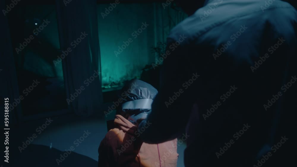 African American police officer walking with flashlight through dark ...