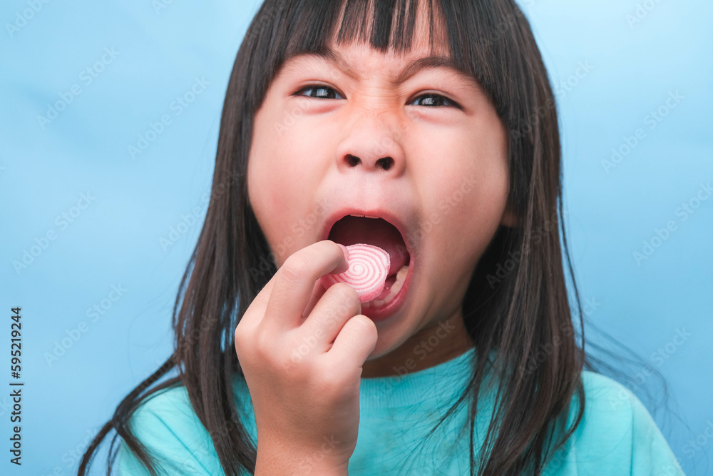 Smiling cute little girl eating sweet gelatin with sugar added isolated ...