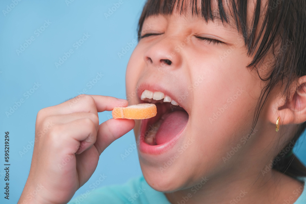 Smiling cute little girl eating sweet gelatin with sugar added isolated ...
