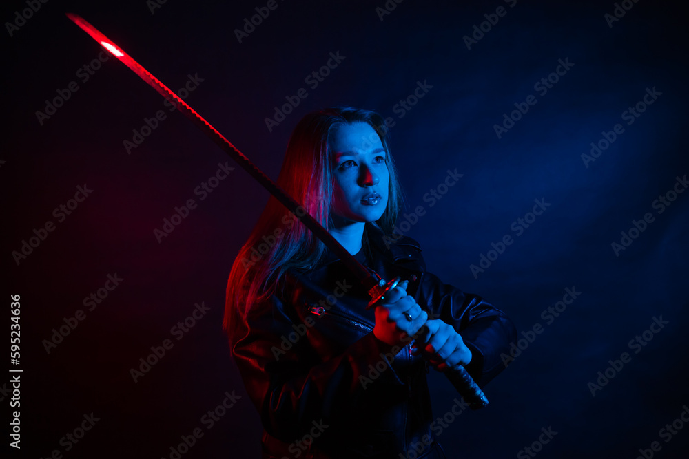 A young beautiful woman with long hair in a black leather jacket holds ...