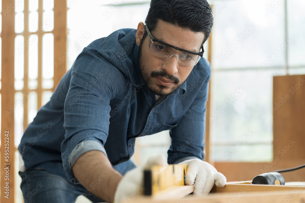 Professional male carpenter using water level meter or spirit level ...