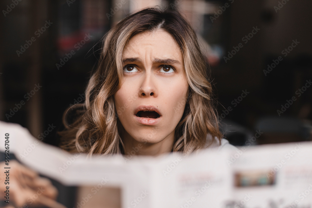 Upset casual woman reading newspaper and look sad while standing at ...