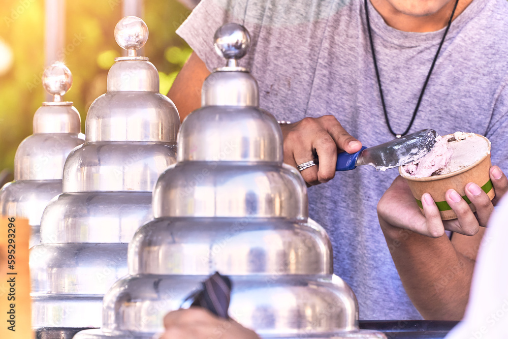 Employee serving ice cream on a classic italian style scream stand ...