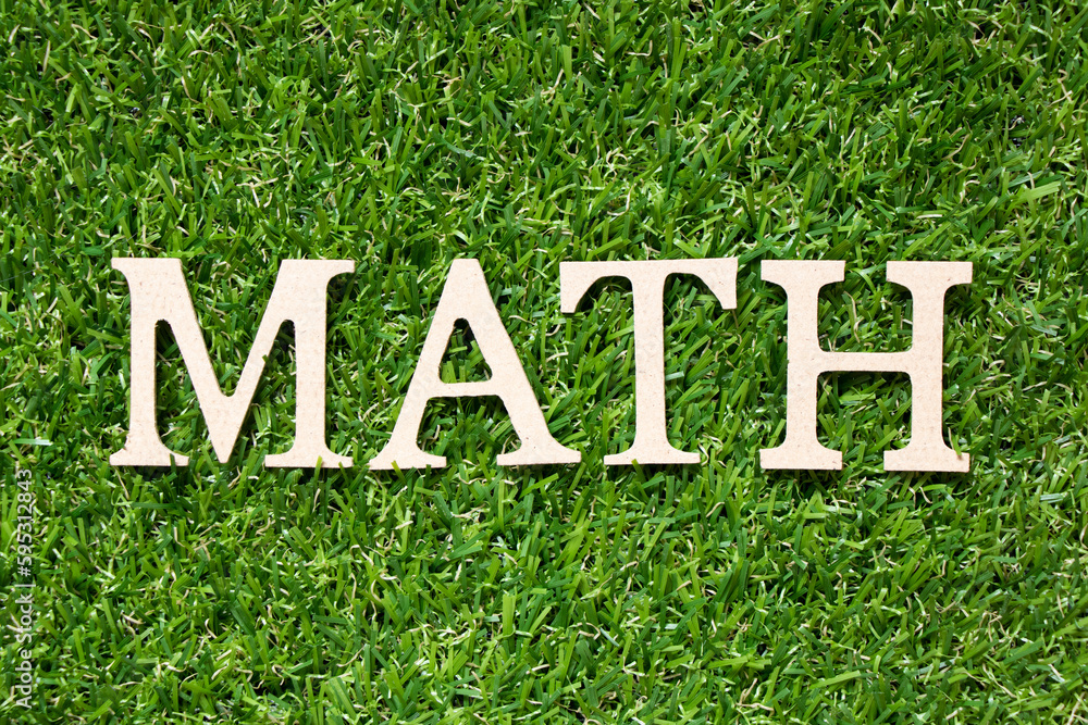 Wood alphabet letter in word math on artificial green grass background ...