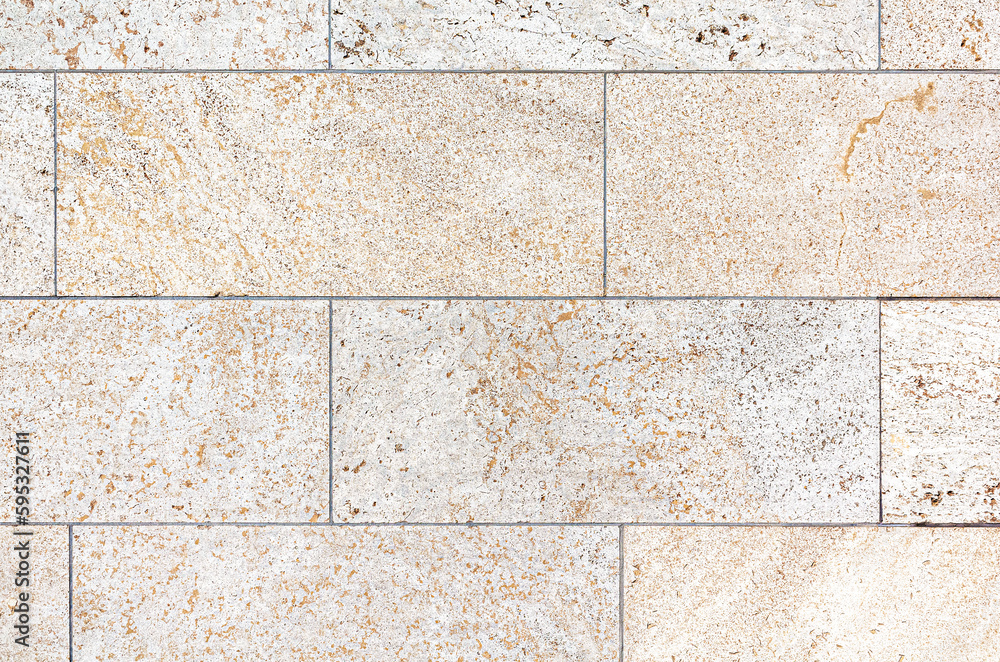 texture of a tiled beige stone wall as background, natural stone wall ...