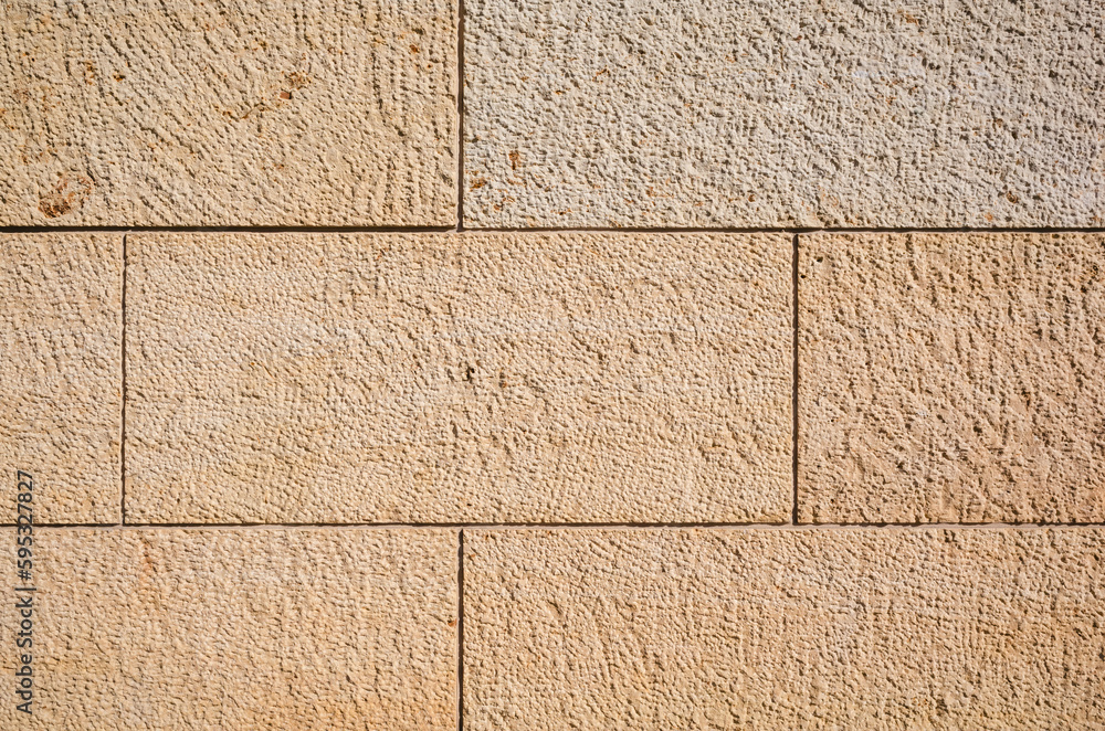 texture of a tiled beige stone wall as background, natural stone wall ...