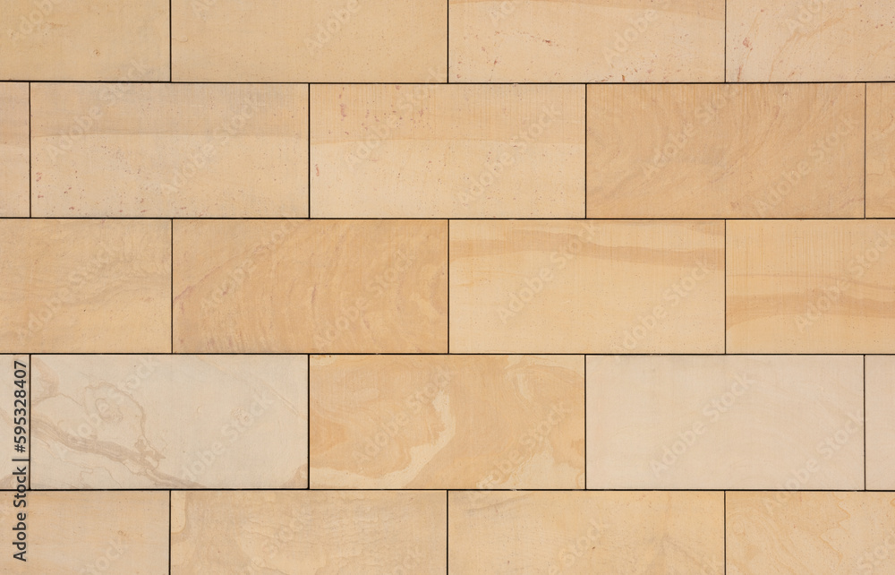 texture of a tiled beige stone wall as background, natural stone wall ...