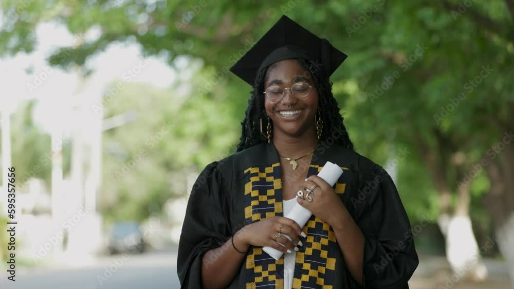 Portrait of Black Female University Graduate wearing black gown and cap ...