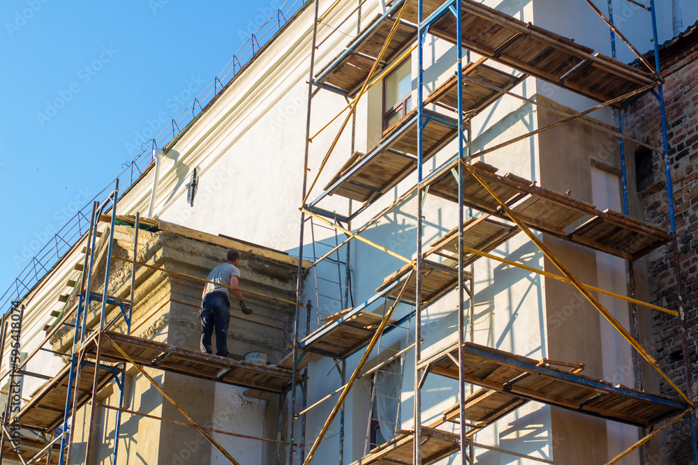 Builder on the scaffolding works on the restoration of the monastery in ...