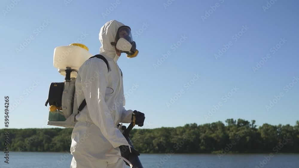 Young disinfectant, man with a spray gun in his hands, a sanitary ...