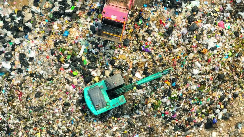 Garbage piles are cleared by workers who operate excavators to scoop ...