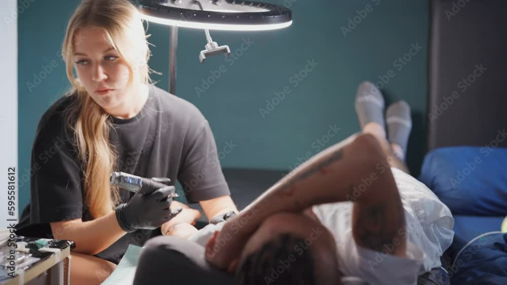 tattooing close-up tattoo artist shows the process of applying black ...