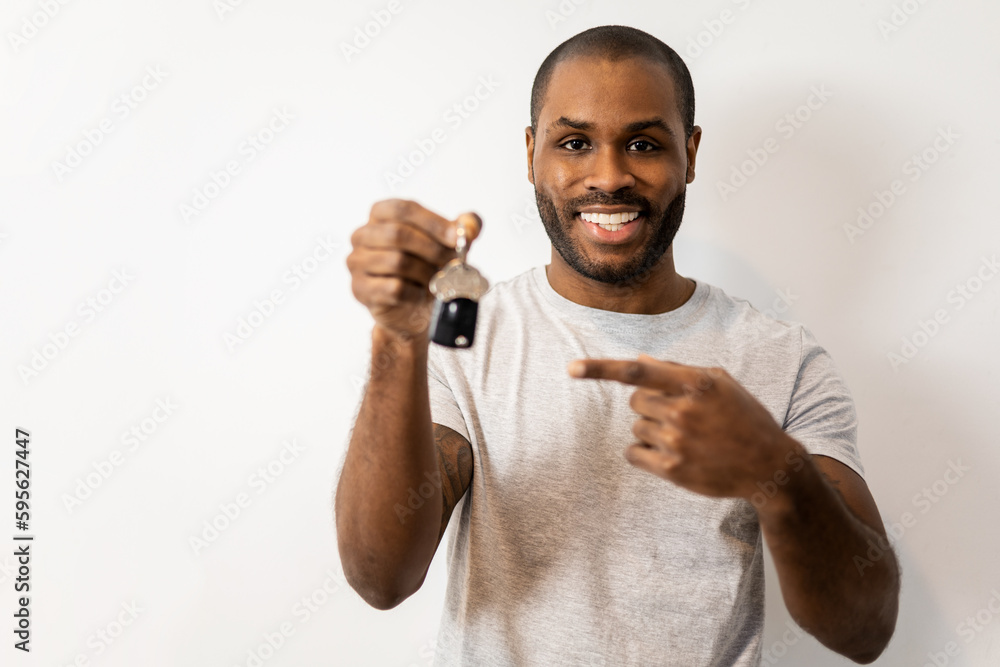 A smiling dark-skinned man poses against a white background while ...