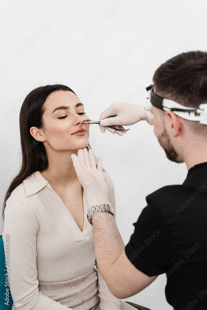 Otolaryngologist examines girl nose before procedure of endoscopy of ...