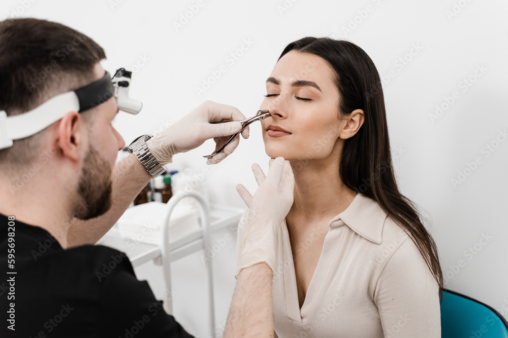 Consultation with ENT doctor. Otolaryngologist examines girl nose ...