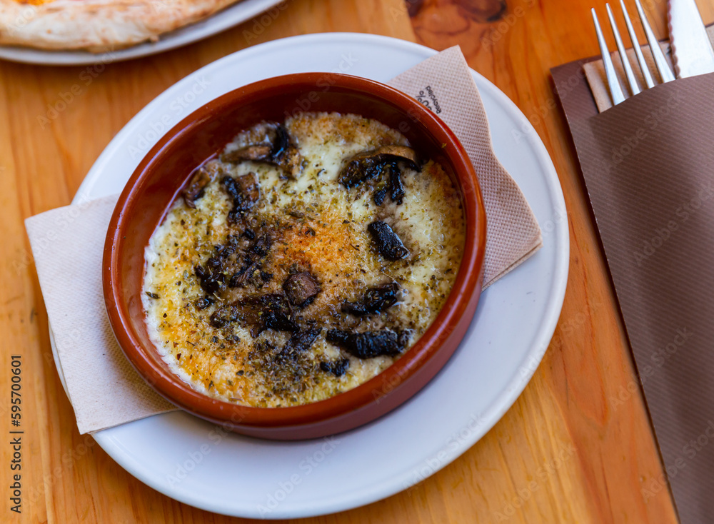 Delicious browned baked provolone cheese with champignon mushrooms ...