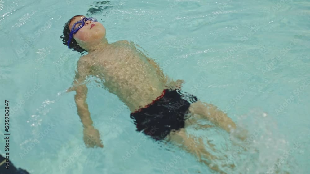swimming pool training class: little boy learning swim, floating water ...