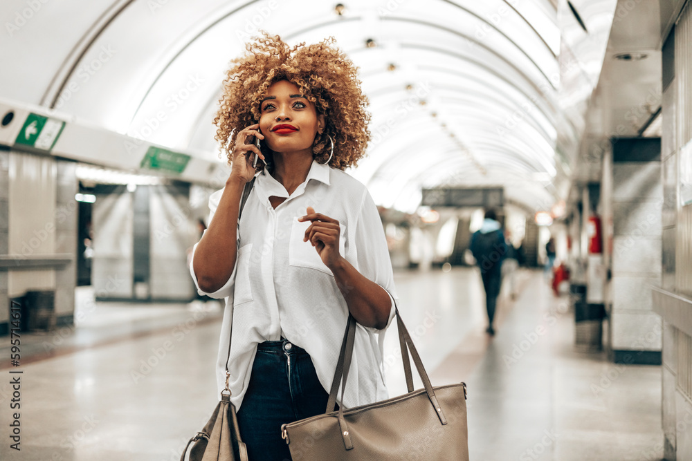 Beautiful fashionable black woman standing at a subway train station ...